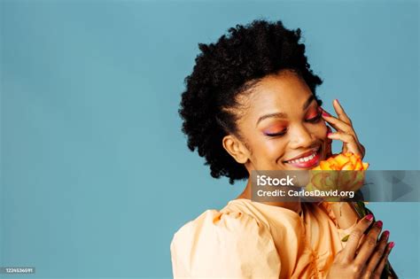 노란 주황색 장미를 들고 푸른 배경에 고립 된 눈을 감고 미소 짓는 행복한 젊은 여성의 초상화 향기로운에 대한 스톡 사진 및 기타 이미지 Istock