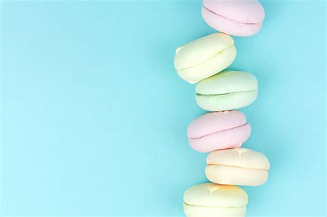달콤하고 다채로운 마시멜로는 프렌치 마카롱처럼 보입니다 파스텔 블루 배경에 마카롱의 아름다운 다양성 구멍이 많은에 대한 스톡