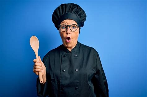 수석 아름 다운 회색 머리 요리사 여자 밥 솥 유니폼과 모자를 들고 나무 숟가락을 들고 깜짝 얼굴 두려움과 흥분 노인에 대한 스톡 사진 및 기타 이미지 Istock
