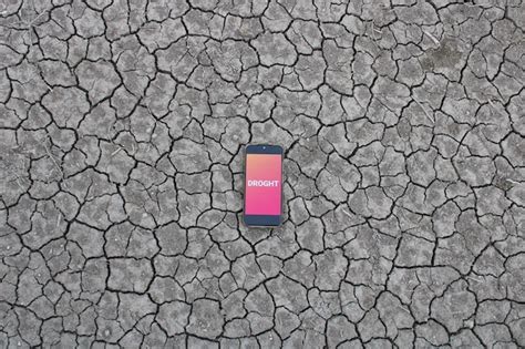 Premium Photo A Phone With A Pink Screen Sits On A Cracked Ground