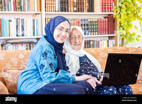 Happy Muslim Grandmother And Her Granddaughter Sitting Together On