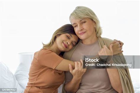 행복한 믹스 피부 가족 함께 살고 아시아 딸과 입양 백인 어머니는 미소와 함께 서로를 껴안고 사랑의 개념과 법률에서 가족 어머니 또는 딸의 시간을 공유 십대에 대한 스톡