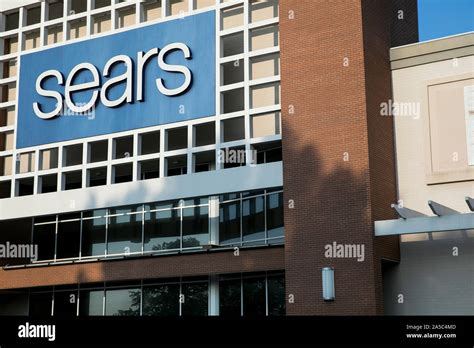 A Logo Sign Outside Of A Sears Retail Store Location In Greensboro