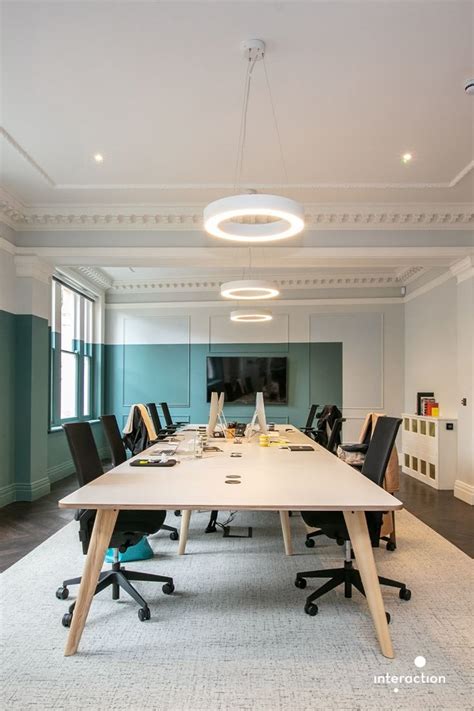 An Empty Conference Room With Chairs And A Large White Table In The