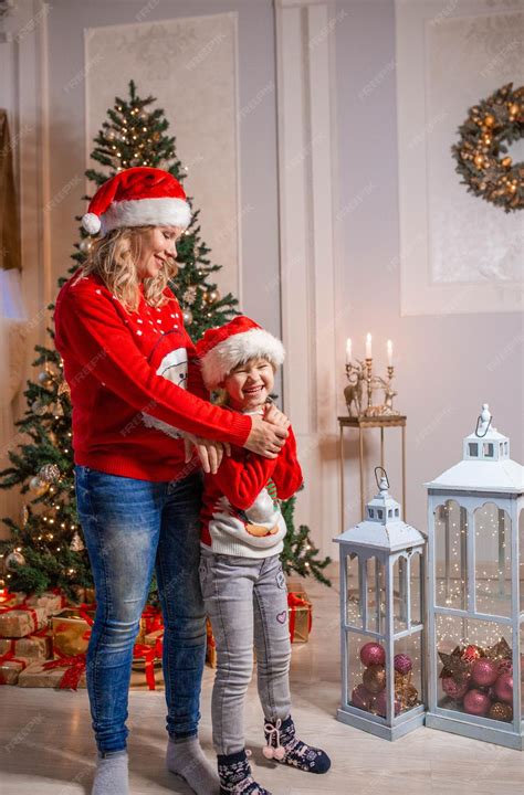 Mãe Feliz E Filha Rindo Em Suéteres De Natal Ficam Ao Lado Da árvore De
