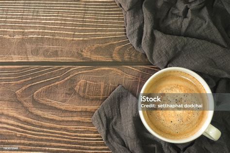 카푸치노 또는 라떼 커피를 화이트 세라믹 컵 커피에 우유 거품과 천연 목재 질감 배경에 냅킨으로 클로즈업 복사 공간이 있는 맨