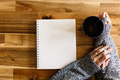 메모장 옆에 커피 한 잔을 들고 있는 여자 사진 Unsplash의 무료 쓰기 이미지
