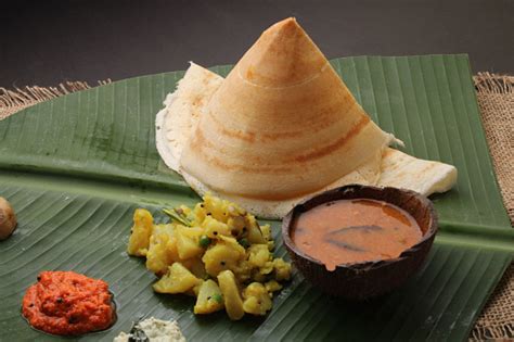 Paper Masala Dosa는 신선한 바나나 잎 위에 삼바르와 코코넛 처트니와 함께 제공되는 남부 인도 식사입니다 0명에