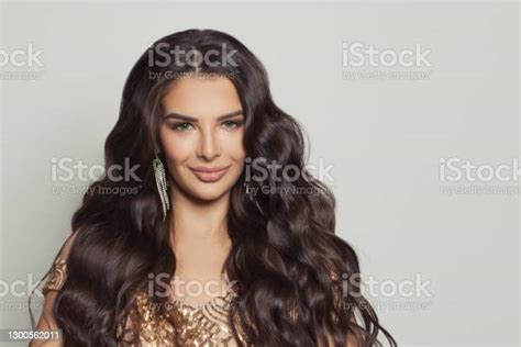 흰색 배경에 포즈 골드 이브닝 가운을 입고 긴 곱슬 머리와 완벽한 갈색 머리 모델 여자 25 29세에 대한 스톡 사진 및 기타 이미지 25 29세 갈색 갈색 머리