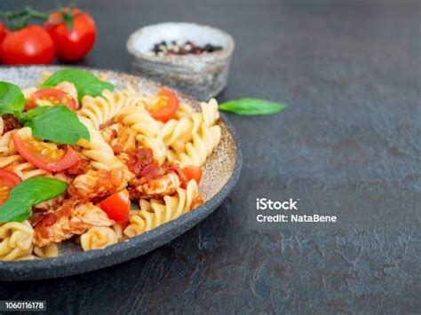 Fusilli 토마토 소스 파스타 바 질와 치킨 필렛 어두운 돌 콘크리트 배경 측면 보기 클로즈업 복사 공간에 나뭇잎 건강한