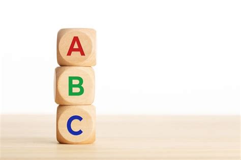 木製のテーブルに積み上げられた木製のブロックにabc文字のアルファベット。 プレミアム写真