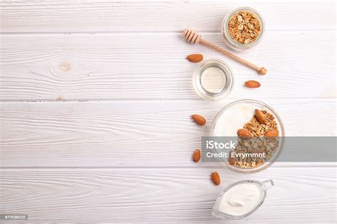 우유와 백색 나무 테이블 평면도에 그리스 요구르트와 아몬드 캐슈 너트 건조 과일 그 라 놀라 Superfood 건포도 유리에 벚꽃 좀더 야쿠르트에 대한 스톡 사진 및 기타
