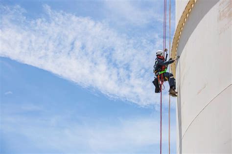 남성 작업자 다운 높이 탱크 루프 로프 액세스 저장 탱크 가스의 안전 검사 두께 용접 프리미엄 사진