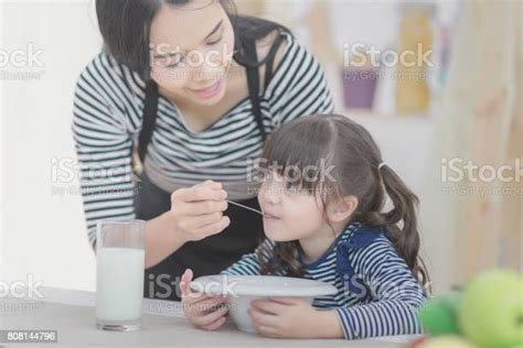 아침에 그녀의 귀여운 딸에 게 건강 한 아침 식사를 먹이 아시아 어머니 가정 주방에 대한 스톡 사진 및 기타 이미지 가정