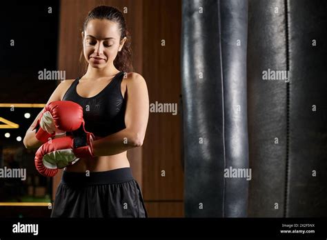 A Brunette Sportswoman In Black Active Wear Throwing Punches With Red
