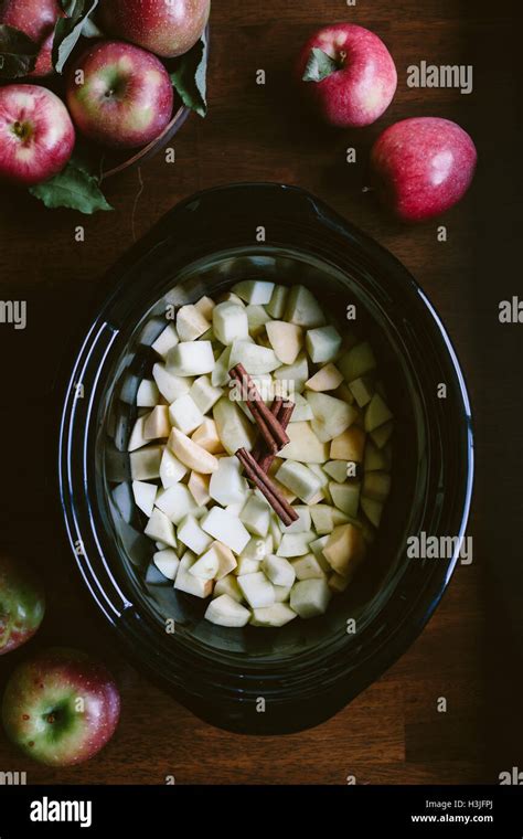 Sliced And Peeled Apples Are Placed In The Bowl Of A Slow Cooker