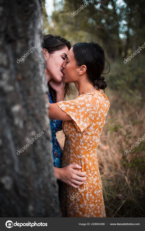 Two Young Lesbians Kissing And Caressing Each Other In The Woods Stock