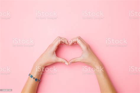 파스텔 핑크 바탕에 젊은 여자의 손에서 만든 심장 모양 사랑과 행복 개념입니다 감정 텍스트 견적 또는 말을 위한 빈 장소 근접