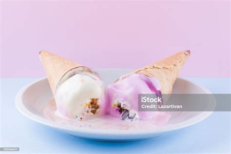 분홍색 파란색 배경에 녹은 아이스크림 흰 접시에 두 개의 아이스크림 콘이 있습니다 와플 콘에 있는 여름 우유 디저트 여름 컨셉