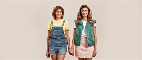 Back View Of Two Young Girls Twin Sisters In Casual Wear Holding Hands