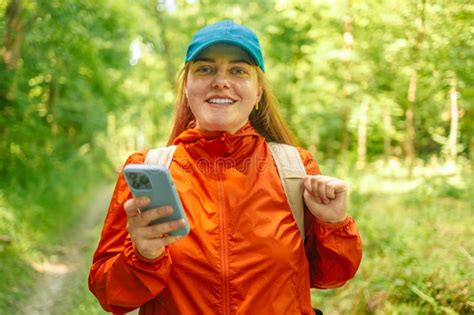Attractive Fit Girl Tourist With A Backpack Using Mobile Phone While