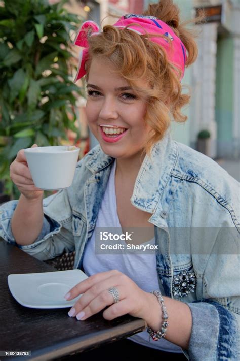 소녀는 거리 카페의 테이블에 앉아 있습니다 아름다운 플러스 사이즈 모델은 봄에 거리의 카페에서 커피를 마신다 20 24세에 대한