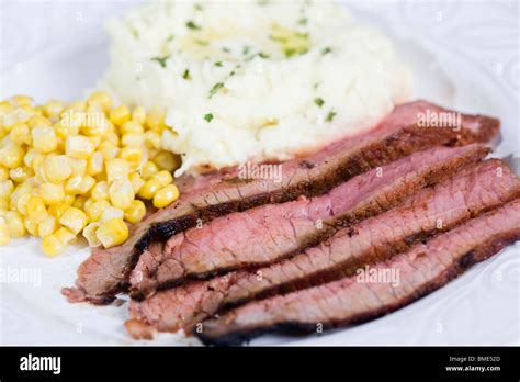 Strips Of London Broil Steak With Sides Of Mashed Potatoes And Corn