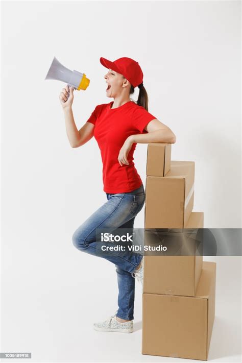 전체 길이 배달 재미의 빨간 모자에 있는 여자 T셔츠 흰색 배경에 고립 여성 택배 확성기 핫 뉴스 빈 골 판지 상자 근처에 서 비명 수신 패키지입니다 공간에 복사 합니다