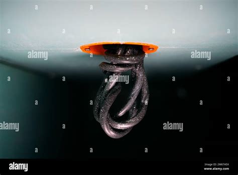 Close Up Of A Thick Black Wire Sticking Out Of An Orange Round Drywall Socket Mortgage For A