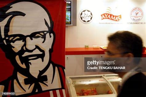 A Delegate Walks Past A Banner Of Kfcs Colonel Sanders At An Photo
