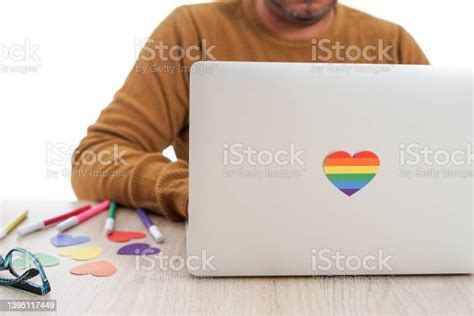 인식 할 수없는 성숙한 남자는 Lgbtq 운동의 색깔과 그 옆에 여러 개의 하트와 컬러 마커가있는 마음을 가진 컴퓨터에서