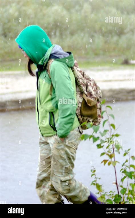 Girl Tourist In A Hood And With A Backpack Is Hands In His Pockets