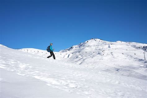 맑은 구름 없는 하늘 아래 눈 덮인 산에서 막대기를 걷는 여성 등산객 걷기에 대한 스톡 사진 및 기타 이미지 걷기 겨울