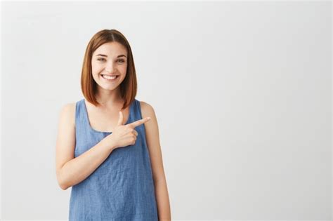Junges Schönes Brünettes Mädchen Lächelnder Zeigefinger In Der Seite Kostenlose Foto