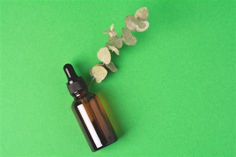 Premium Photo Glass Bottle With Liquid And Eucalyptus On A Green
