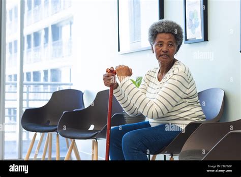 African American Senior Woman With Walking Stick Sitting In Hospital