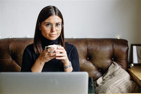 테이블에 앉아 노트북에 메모를 하는 젊은 비즈니스 여성 테이블에는 노트북 스마트폰 및 커피 한 잔이 있습니다 블로거 검사 보기에 대한 스톡 사진 및 기타 이미지 Istock