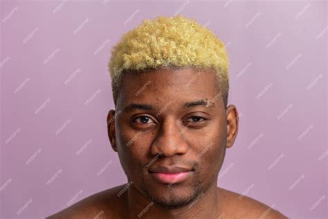 스튜디오에서 파스텔 보라색 배경에 짧은 금발 머리를 가진 젊은 흑인 남자의 헤드샷 프리미엄 사진