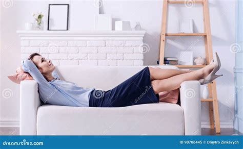 Positieve Gelukkige Vrouw Die Op De Bank Rusten Stock Afbeelding