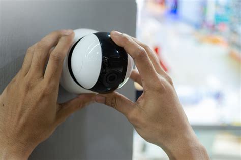 기술자는 벽에 무선 Cctv 카메라를 설치하고 인터넷에 연결하고 스마트 폰 이나 태블릿을 통해 카메라를 제어 할 수 있습니다