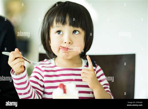 Girl Licking Cream That Stuck To Her Cheek Stock Photo Alamy