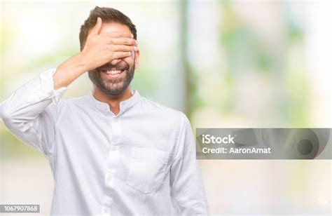 놀람에 대 한 눈을 덮고 얼굴에 손으로 웃 고 웃 고 고립 된 배경 위에 성인 히스패닉 남자 눈 먼 개념입니다 가리기에 대한