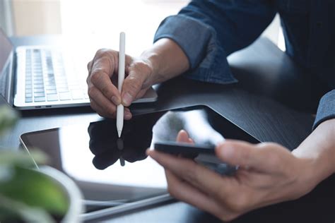 디지털 태블릿에서 스타일러스 펜을 사용하고 사무실 테이블에서 랩톱 컴퓨터에서 작업하는 캐주얼 비즈니스 맨의 클로즈업 전화에 대한 스톡 사진 및 기타 이미지 Istock