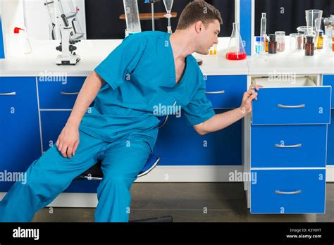Male Lab Assistant Is Looking For Something In A Cases In A Laboratory Healthcare And