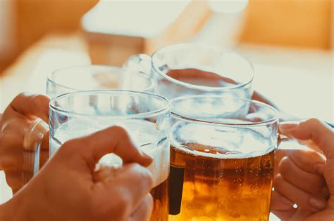 친구는 술집에서 가벼운 맥주 안경 홀 짝 옥 토 버 페스트의 아름 다운 배경입니다 바에서 휴식 하는 동안 젊은 사람들의 그룹입니다 미세 입자입니다 소프트 포커스입니다 얕은