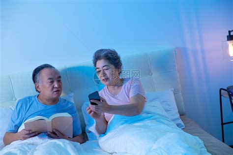 老年夫妇坐在床上看手机高清图片下载 正版图片507659686 摄图网