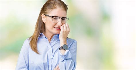 아름 다운 중간 나이 성숙한 비즈니스 여 자가 입을 물고 손톱에 손으로 스트레스와 긴장을 찾고 고립 된 배경 위에 안경을 착용 불안 문제 갈색 머리에 대한 스톡 사진 및