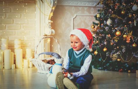 Rapaz Pequeno Com O Boneco De Neve Na Sala De Visitas Decorada Imagem