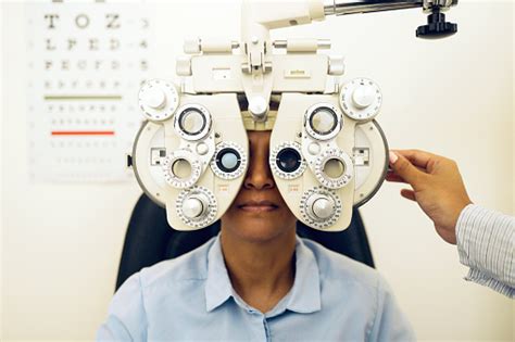 여성 시력 검사 및 검안사 손으로 포롭터 클리닉에서 시력 웰빙 및 건강을 위한 검사 및 렌즈 병원의 평가 상담 및 안경을 위한