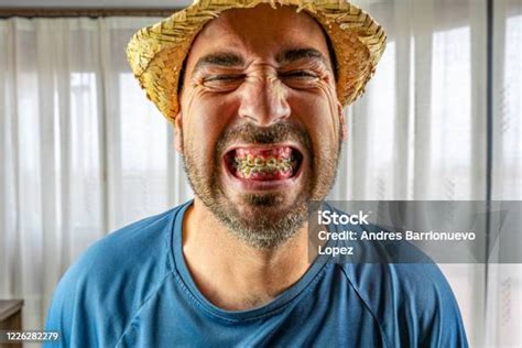 집에서 거실에서 분노의 표정과 어두운 파란색 셔츠를 입고 밀짚 모자를 쓴 수염 남자 개념에 대한 스톡 사진 및 기타 이미지 개념 개념과 주제 남자 Istock